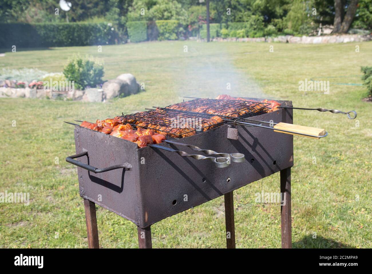 Custom made rusty metal barbeque with meat on it Stock Photo - Alamy