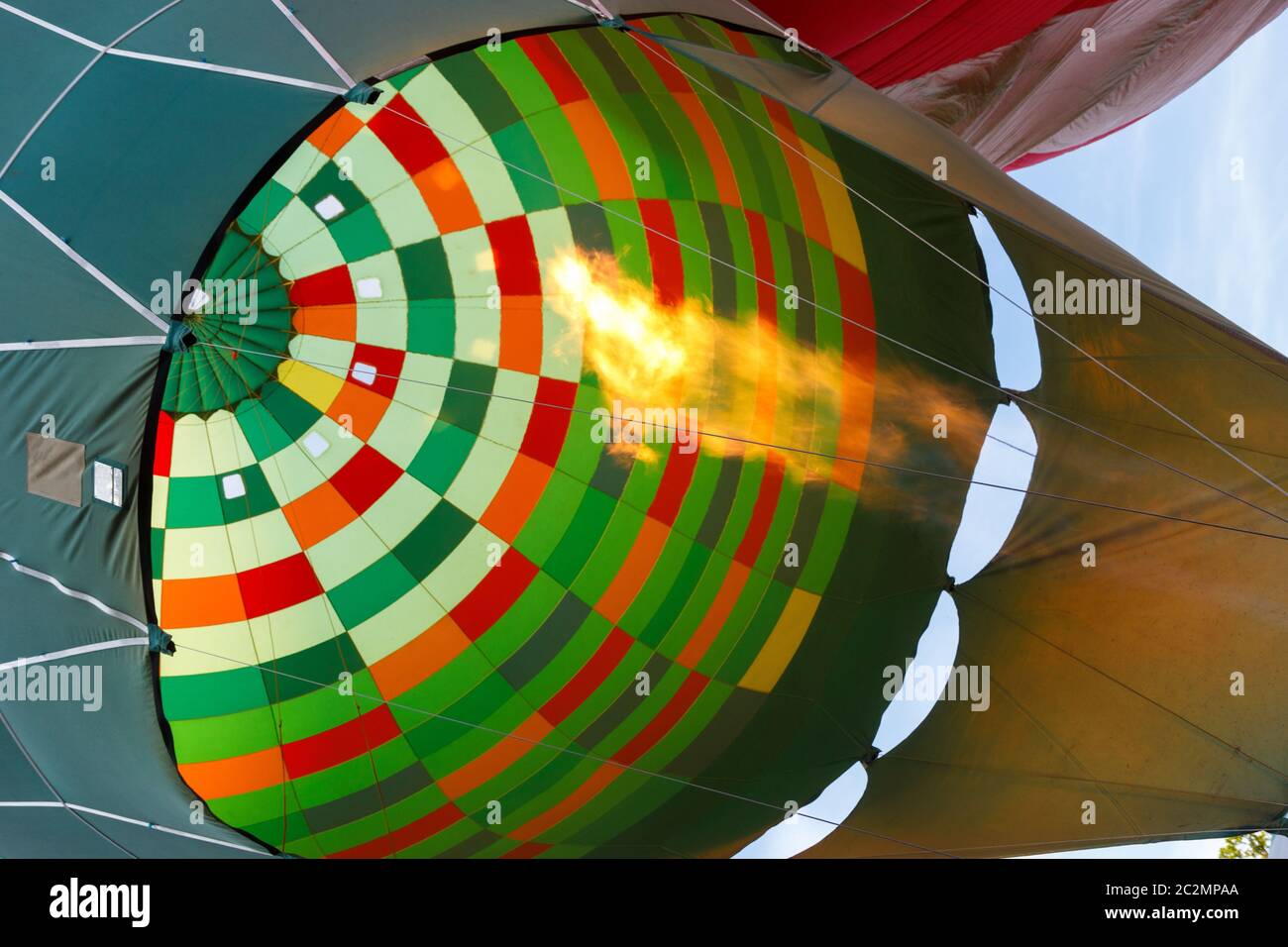A colourful hot air balloon is inflated with hot gas before taking off ...