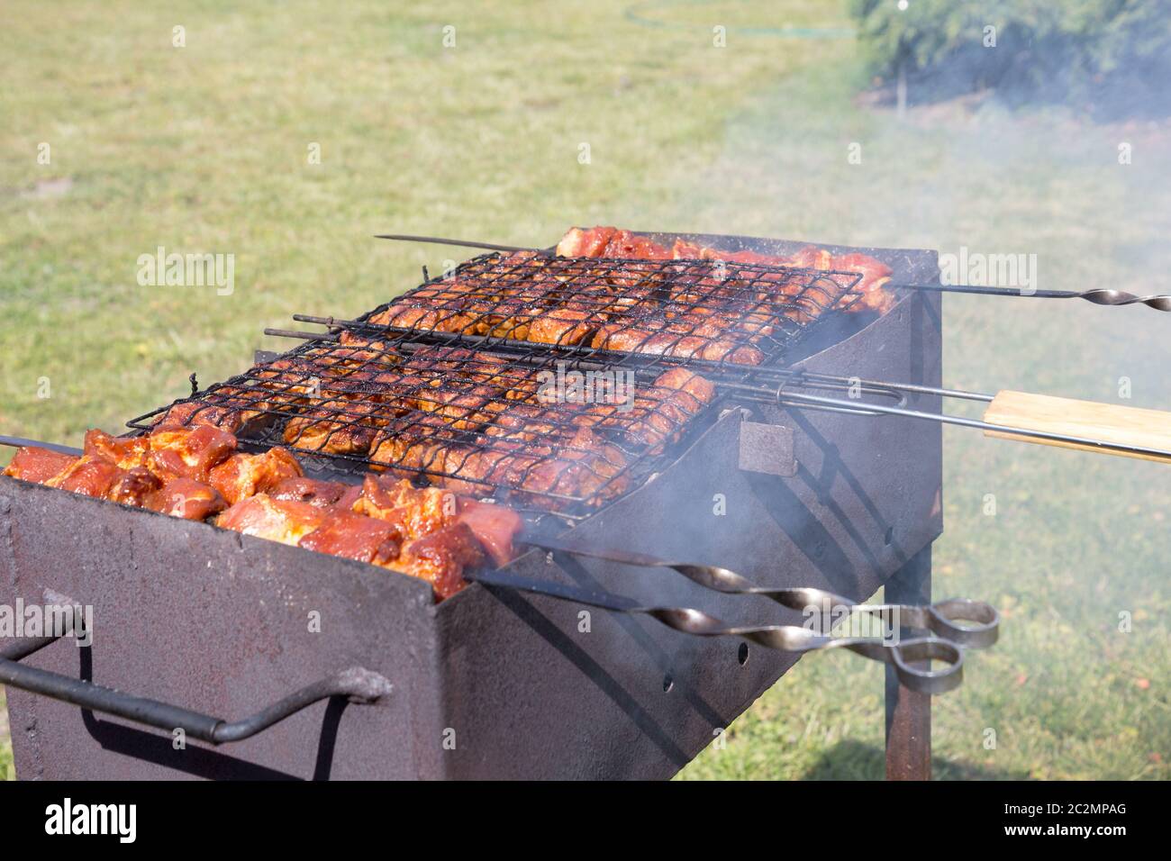 Custom made rusty metal barbeque with meat on it Stock Photo - Alamy
