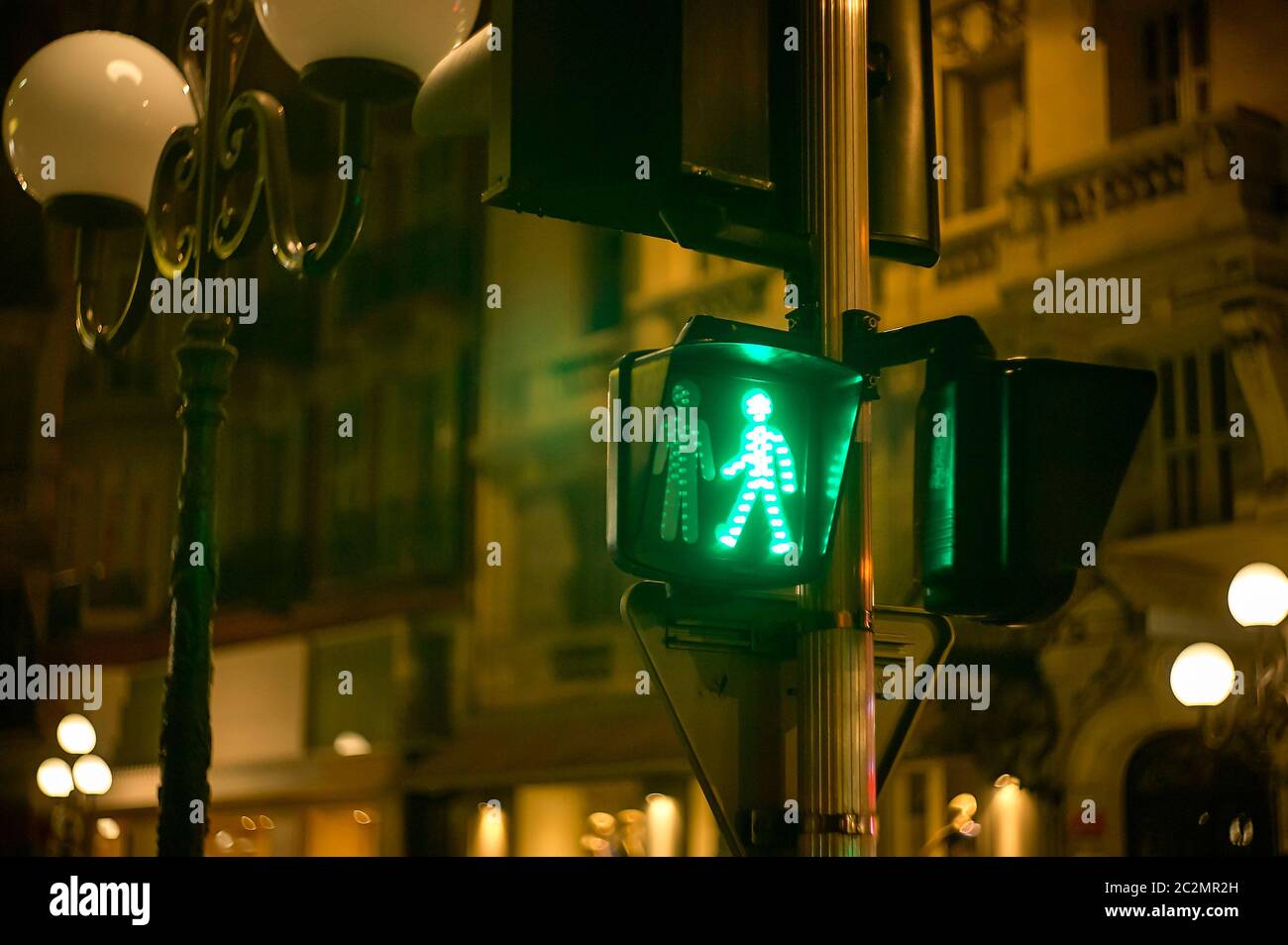 Green pedestrian traffic light in a characteristic street of Nice in ...