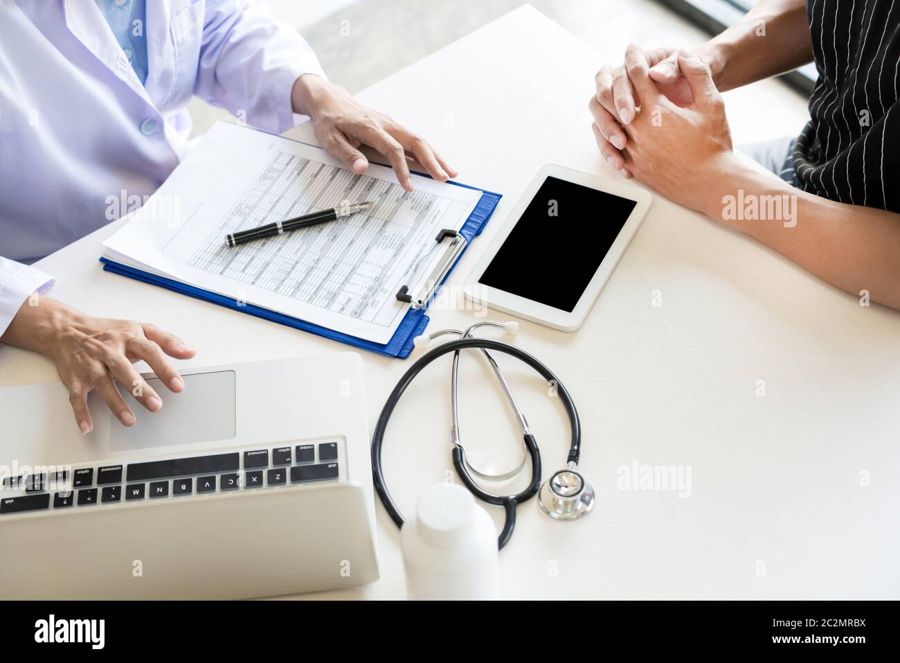 Doctor explaining for patient and showing medical records informations ...