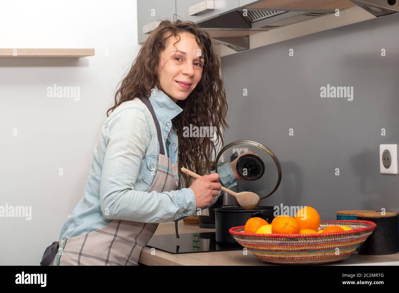 a young woman with long hair is in the kitchen Stock Photo - Alamy