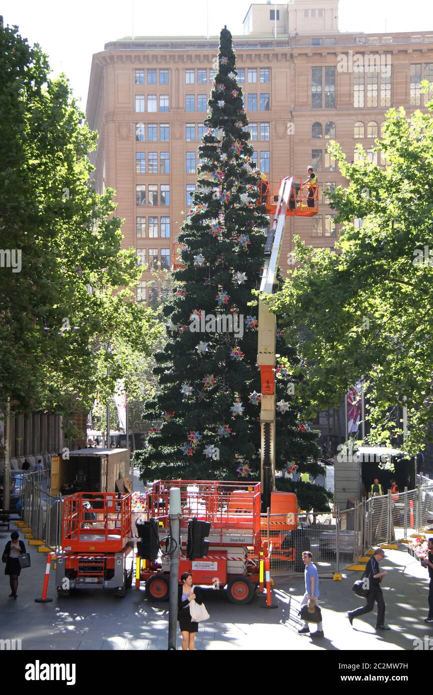 Workers are lifted up in a ‘cherry-picker’ (basket crane) to attach the ...