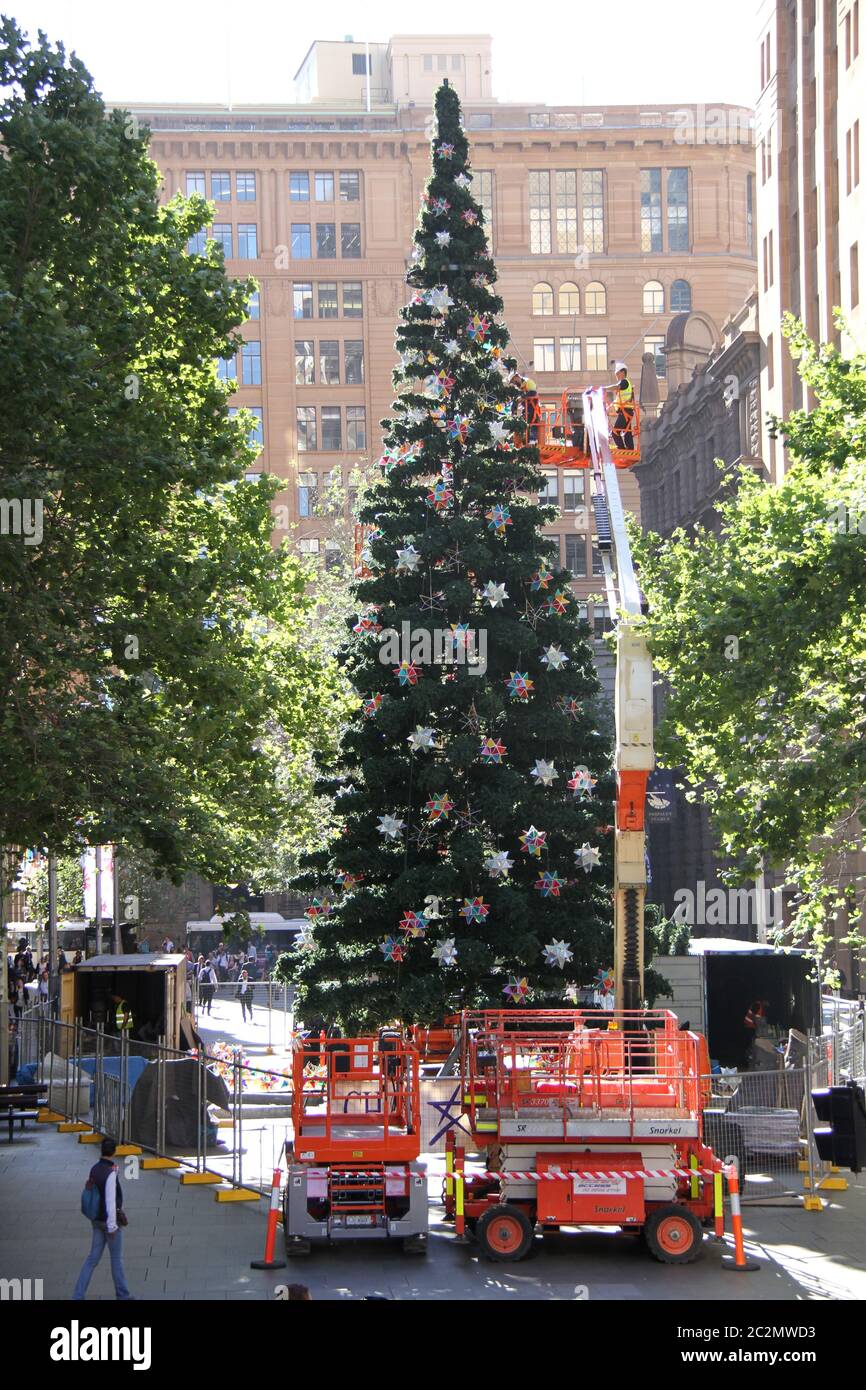 Workers are lifted up in a ‘cherry-picker’ (basket crane) to attach the ...