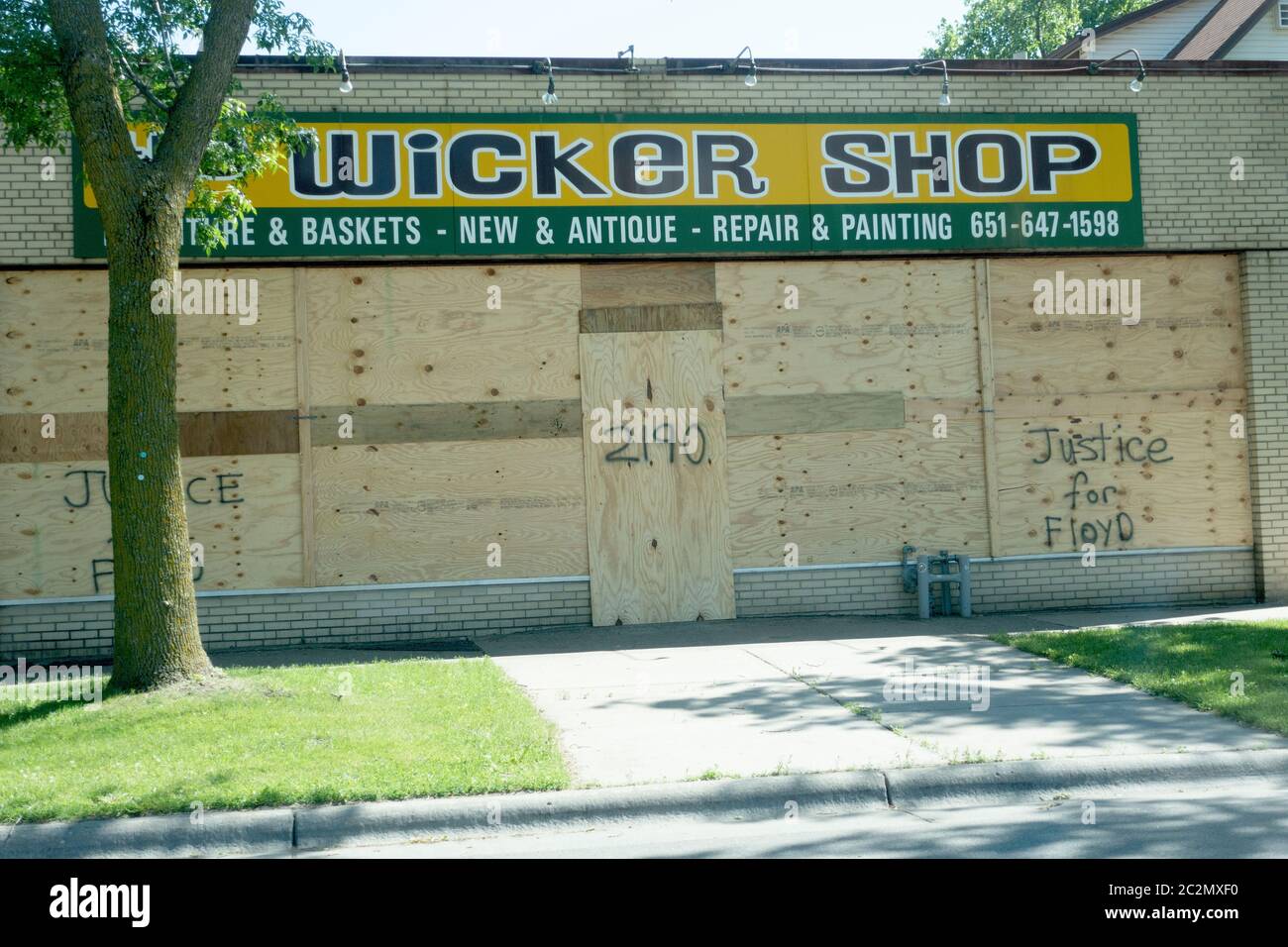 Wicker shop with plywood boarded up windows marked with Justice for ...
