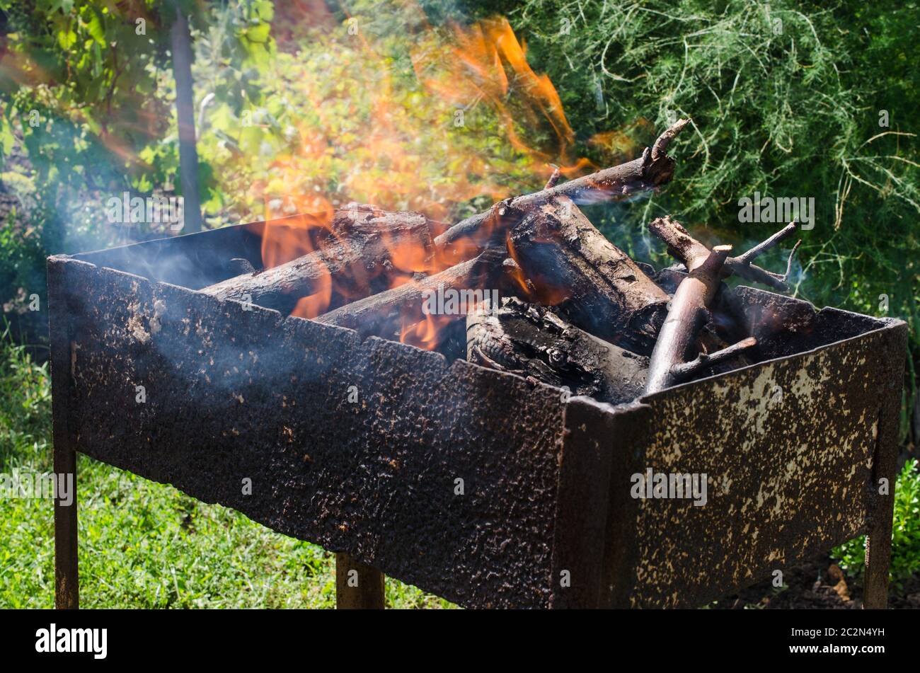 Burning firewood in the barbecue. Bonfire for a picnic. Summer, hot ...