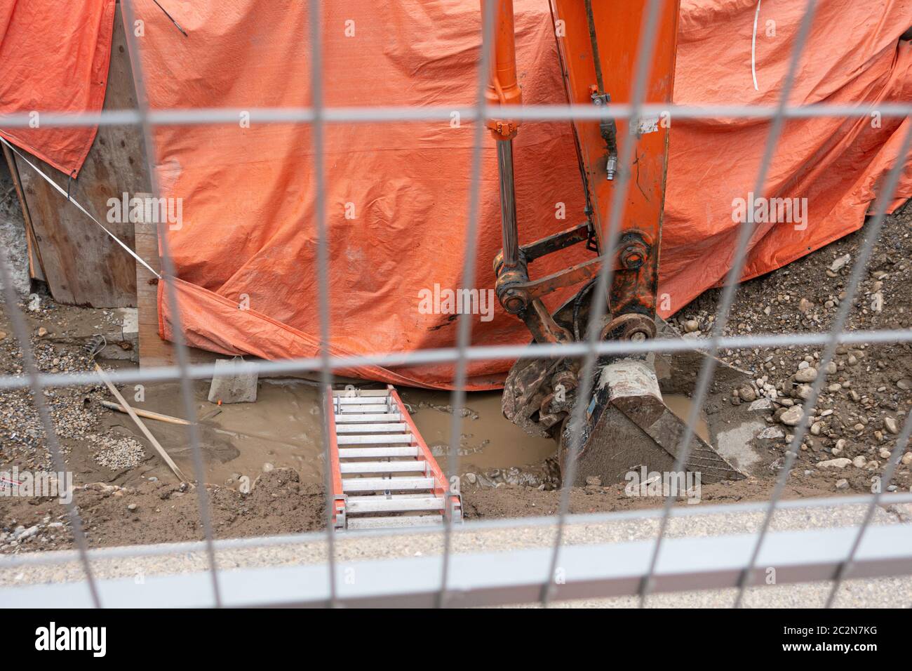 Excavation hole behind wire mesh fence at a downtown city construction ...