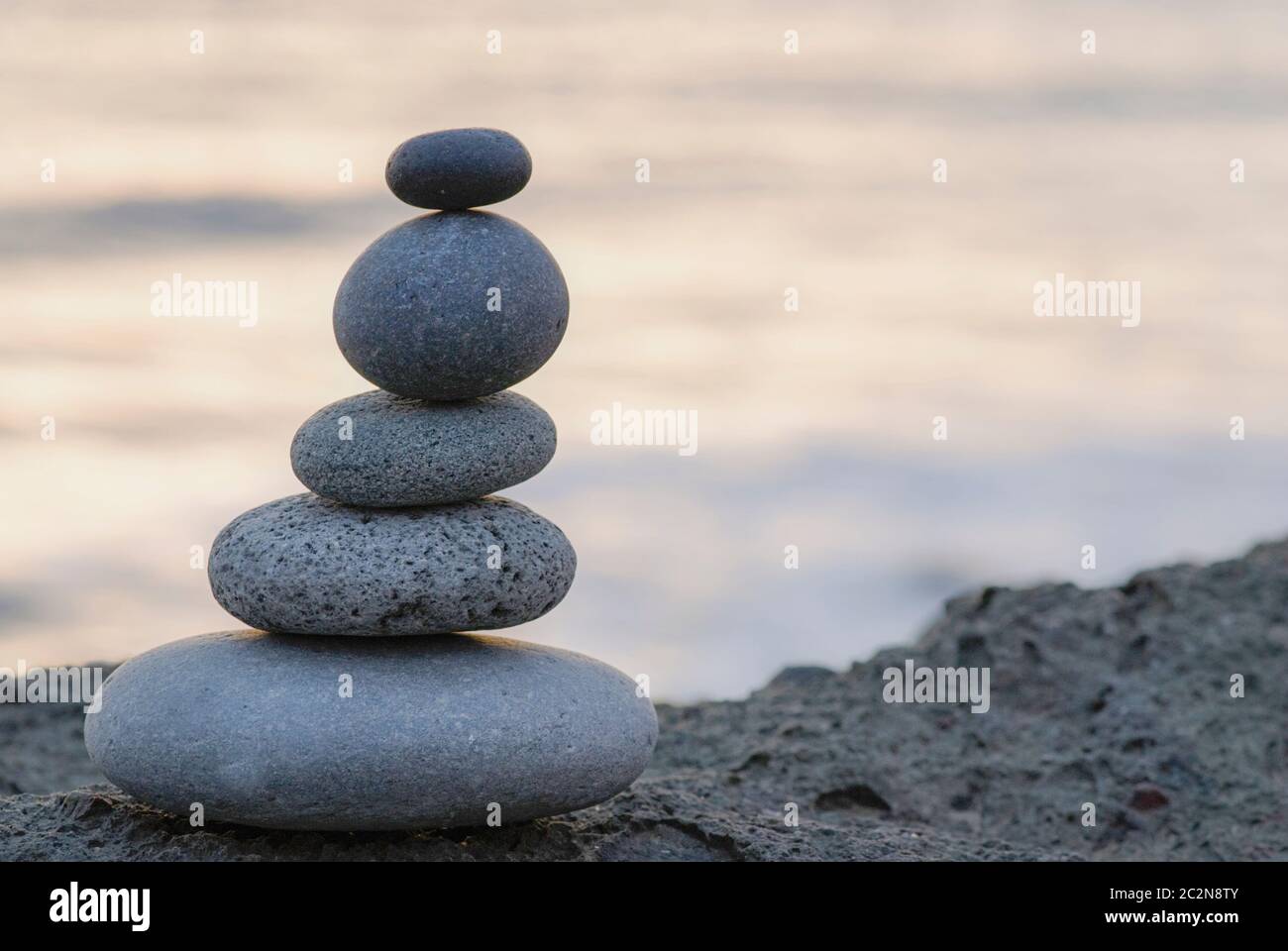 A stack of balanced pebble at the beach with the Atlantic Ocean in the ...