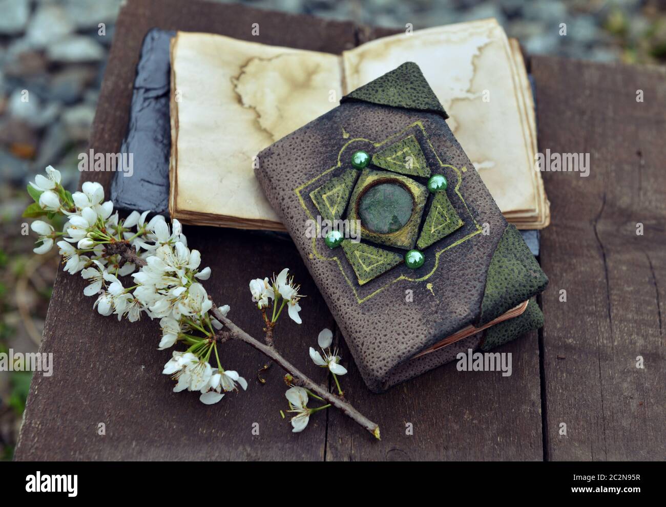 Decorated book and open diary with flowers on planks outdoors. Esoteric ...