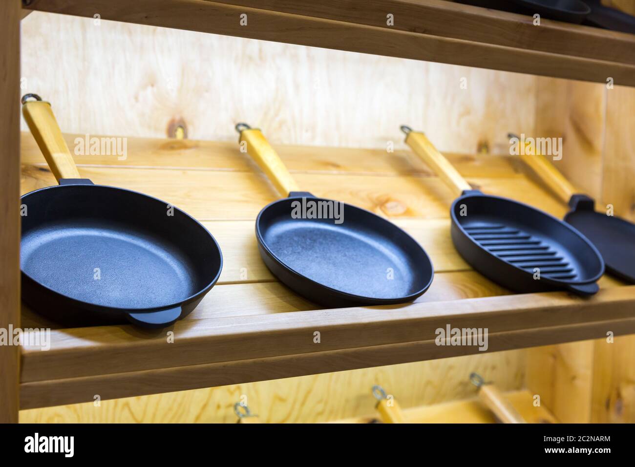 Frying pans on wooden shelf closeup, cooking tools. Kitchen decoration ...
