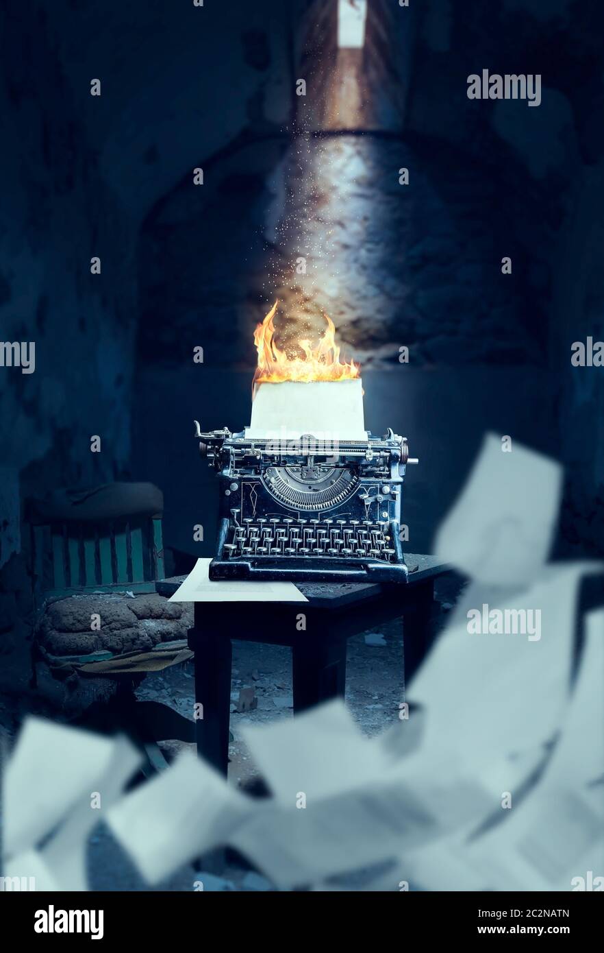 Old typewriter with the inserted burning sheet of paper, grunge room on ...