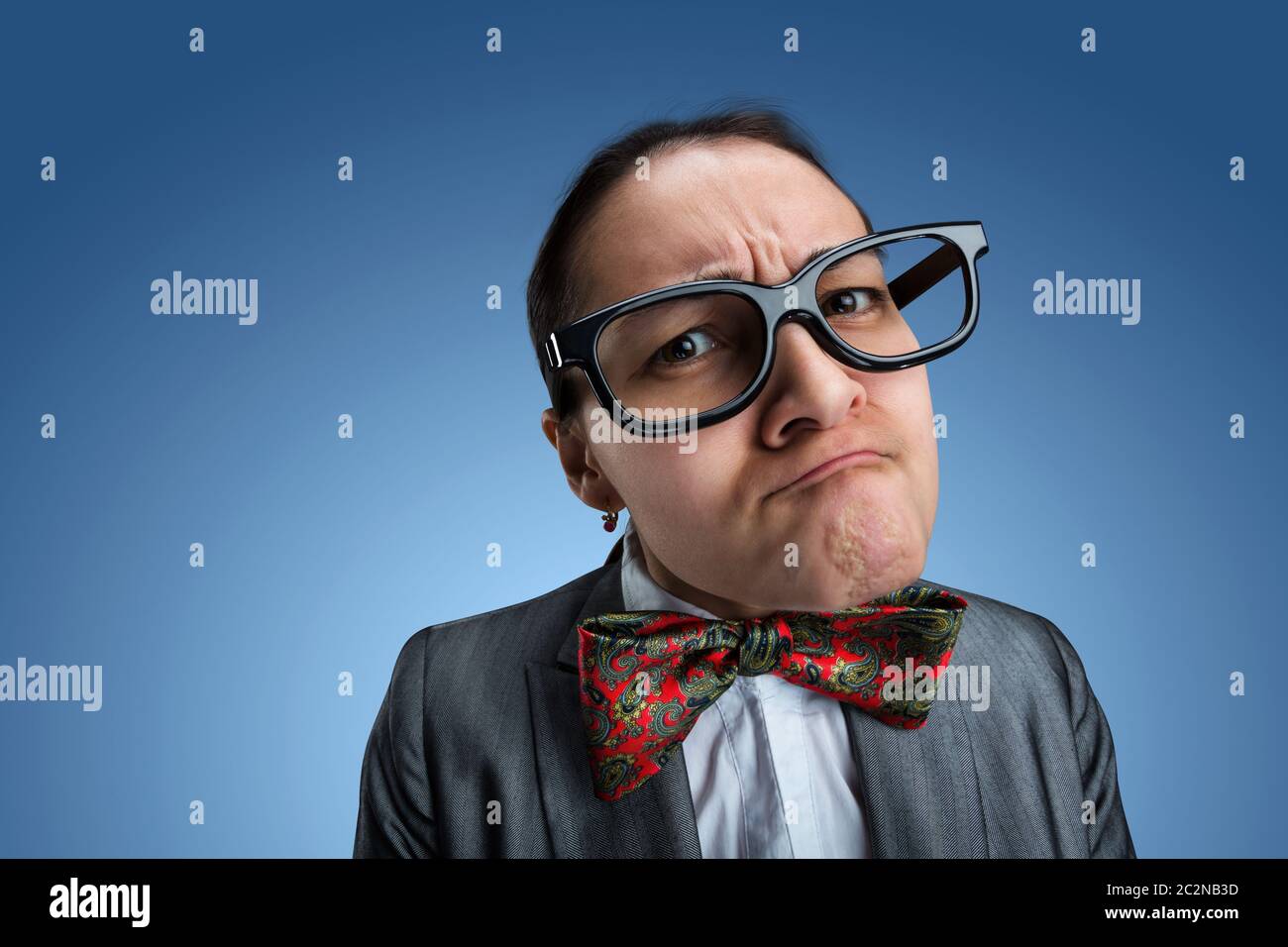 Funny nerd girl in glasses looks at you over blue background Stock ...