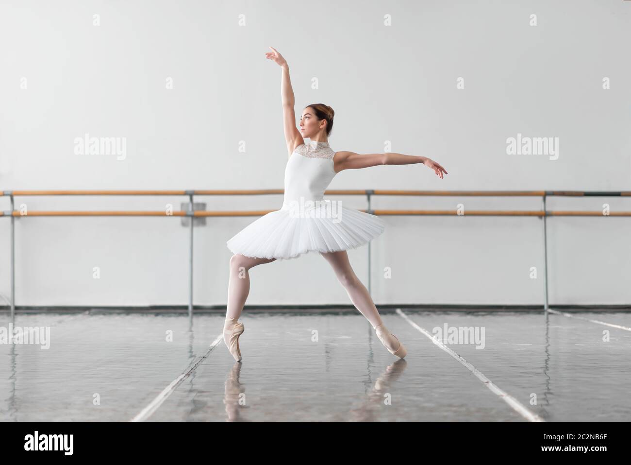 Beautiful female ballet dancer keep the rack in ballet class, barre and ...
