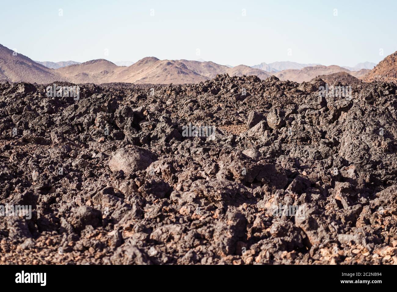 zone of black volcanic rocks in the middle of the desert of Saudi ...