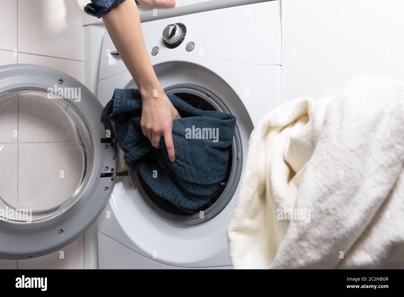 Cleaning and loading white washing machine Stock Photo - Alamy