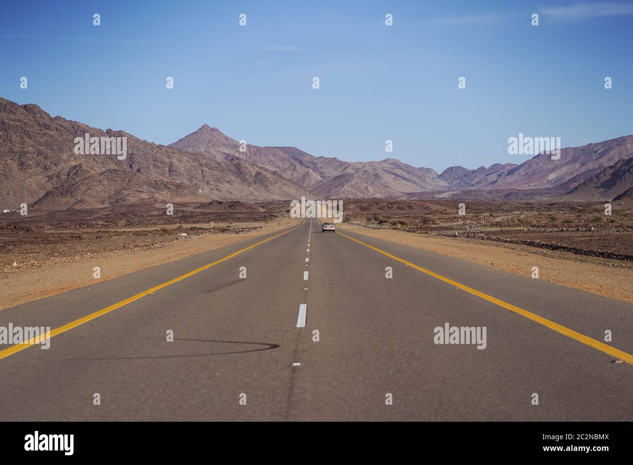 beautiful straight highway surrounded by rock mountains in Saudi Arabia ...