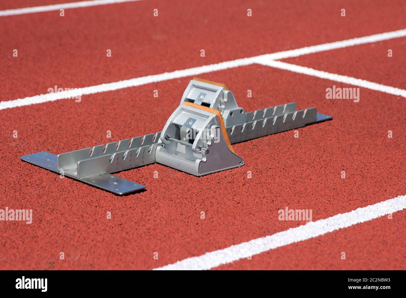 Athletics starting blocks on race red track Stock Photo - Alamy