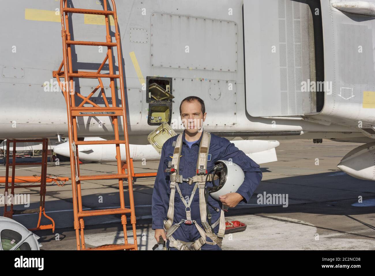 Military pilot with helmet in his hand standing near a jet plane Stock ...