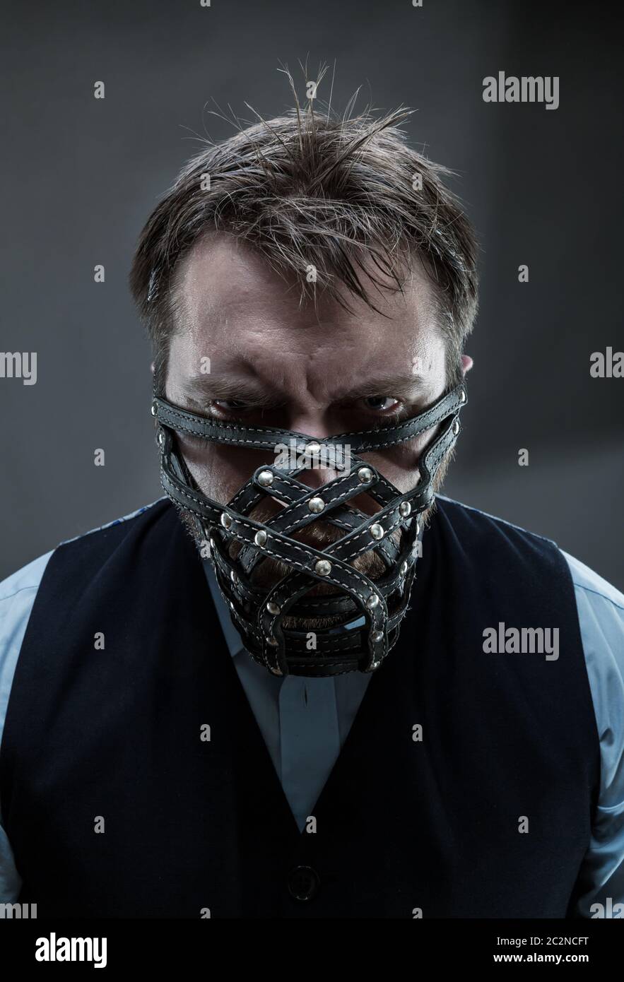 Furious man in muzzle over grey Stock Photo - Alamy