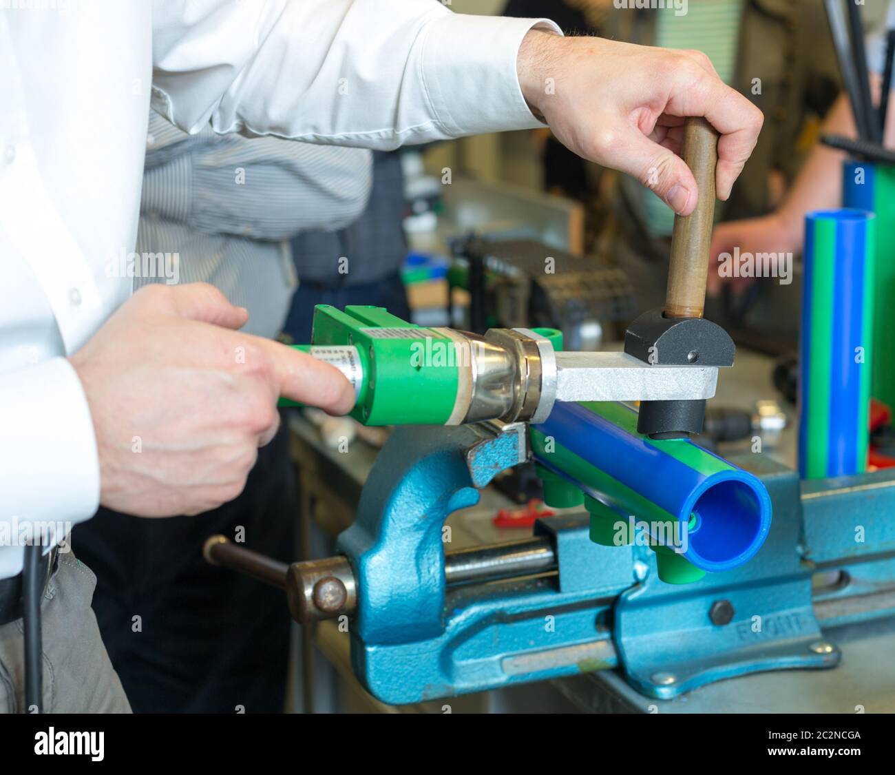Mechanic working with pipes at workroom Stock Photo - Alamy