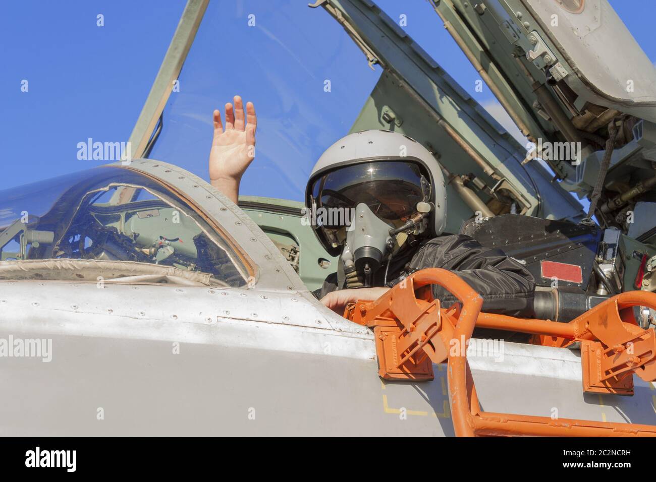 Military pilot in cockpit jet plane with a raised hand Stock Photo - Alamy
