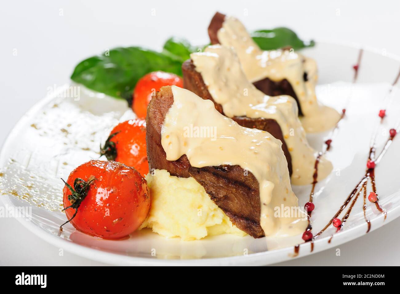 Baked mutton meat with creamy sauce, mashed potato and cherry tomatoes ...