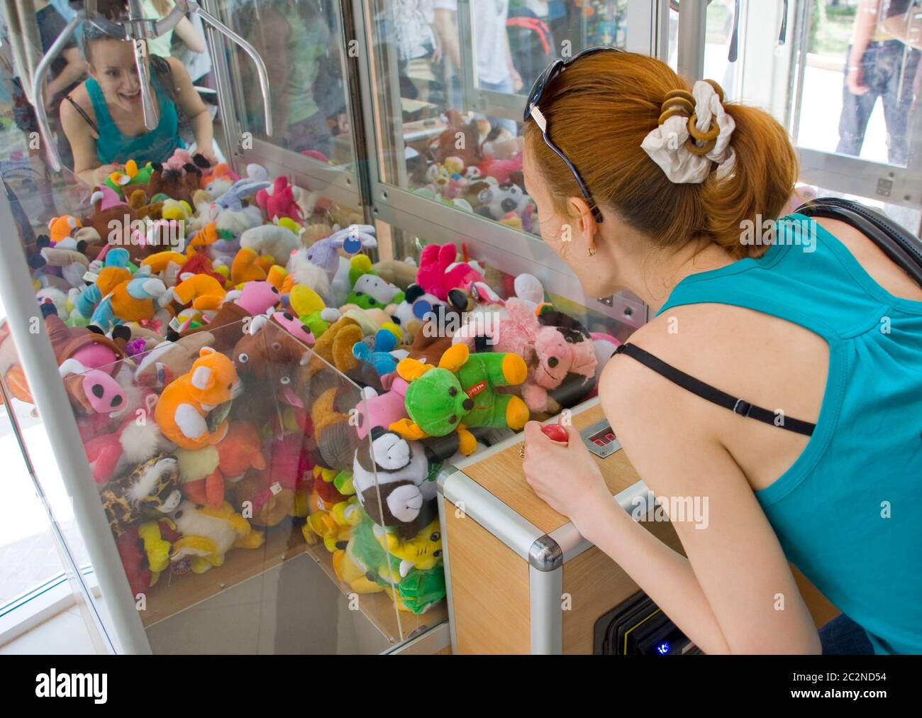Woman playing crane machine Stock Photo - Alamy