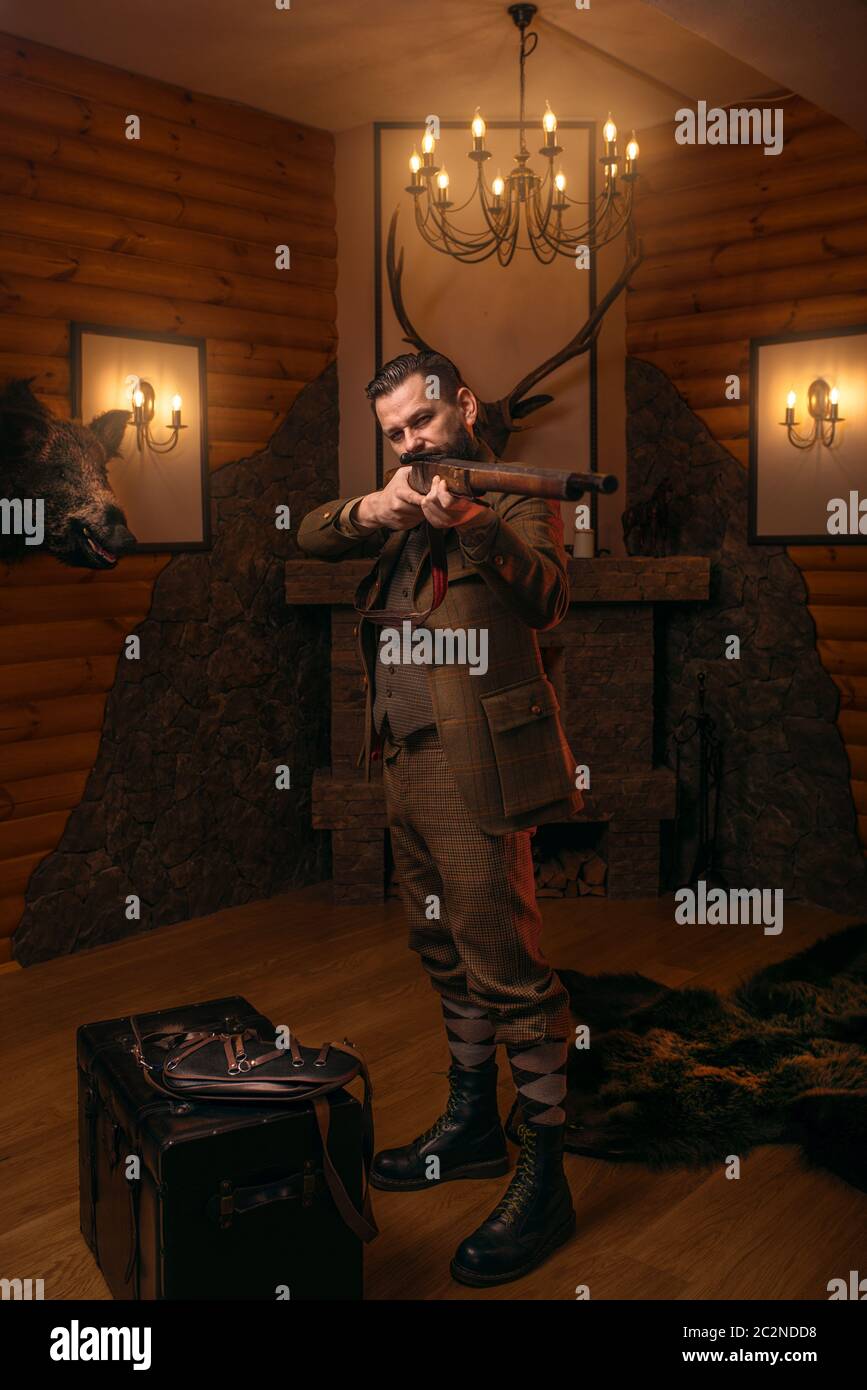 Senior hunter in retro traditional hunting clothing aims of the antique ...