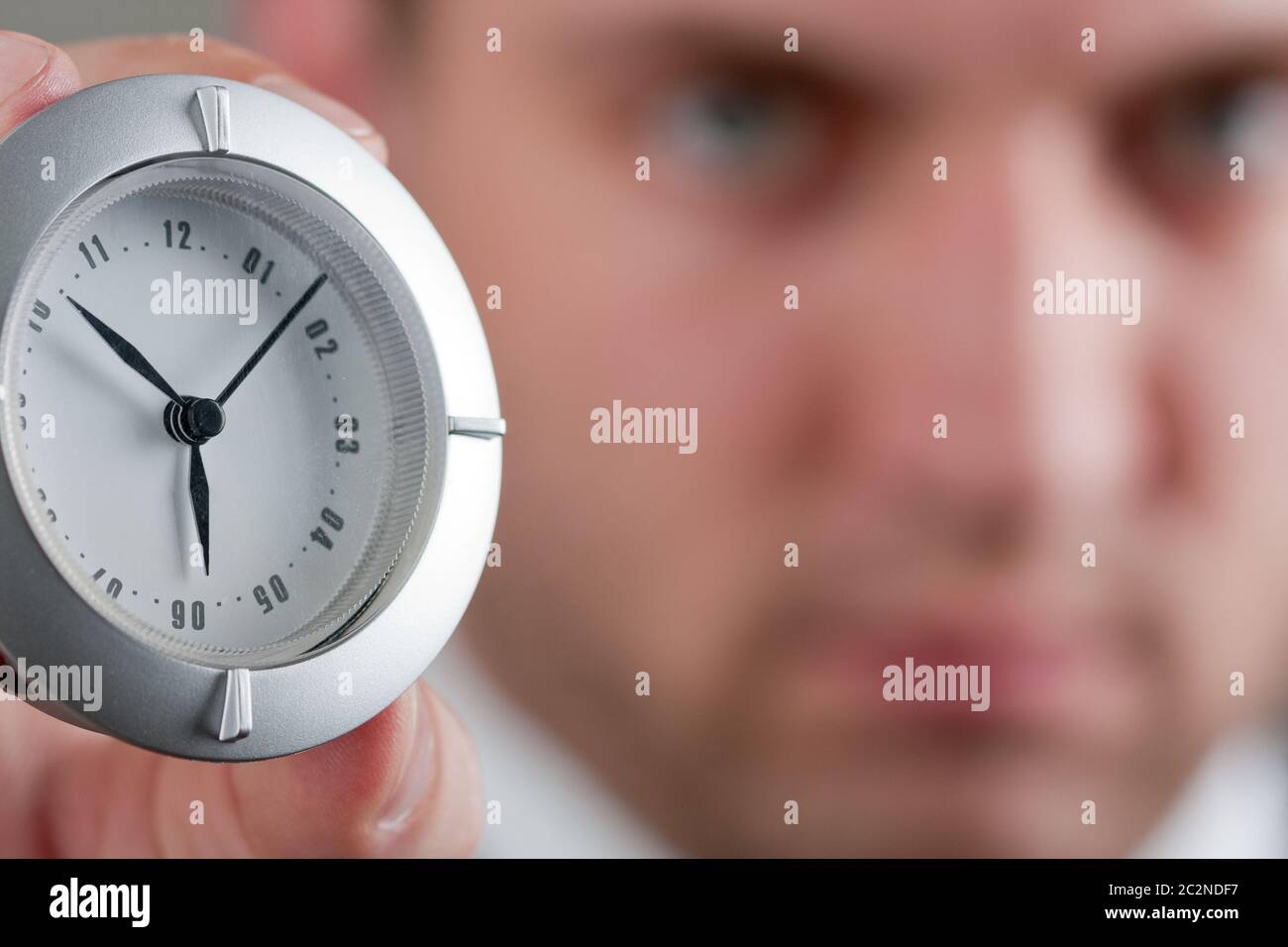 Business time - businessman showing clock to you Stock Photo - Alamy