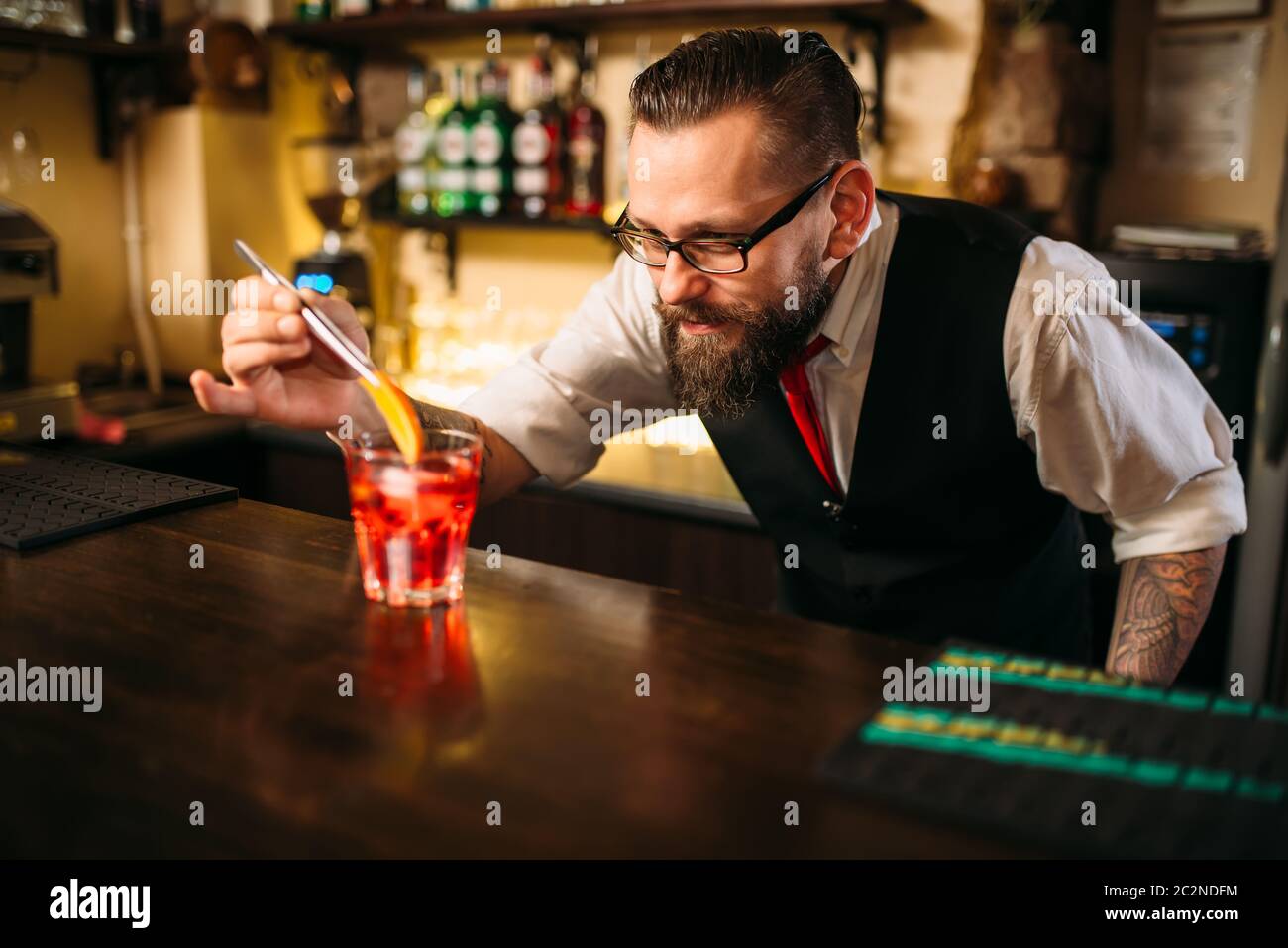 Bartender behind bar counter making alcohol coctail in restaurant Stock ...
