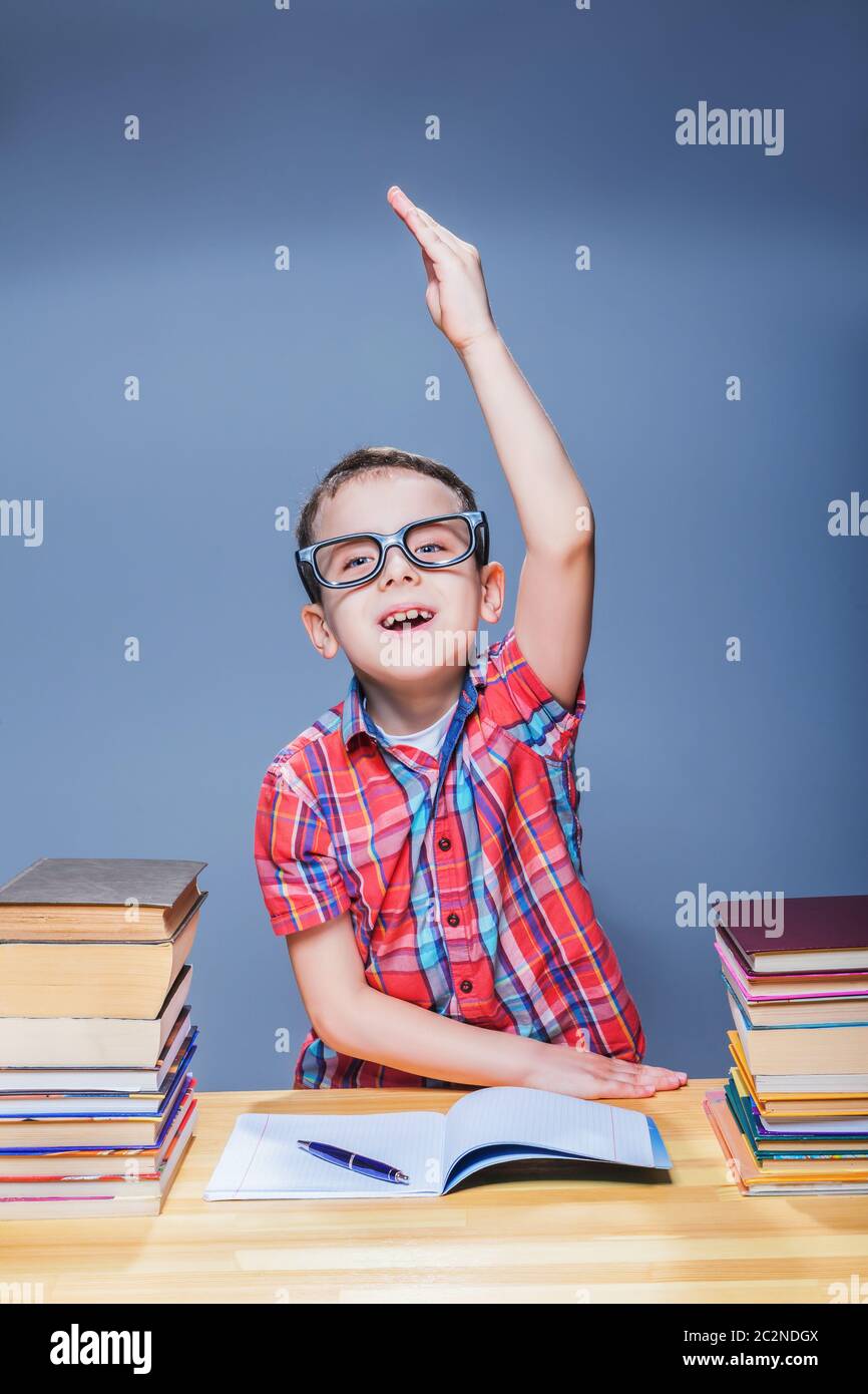 Little pupil pulls a hand up at the lesson in classroom. Education ...