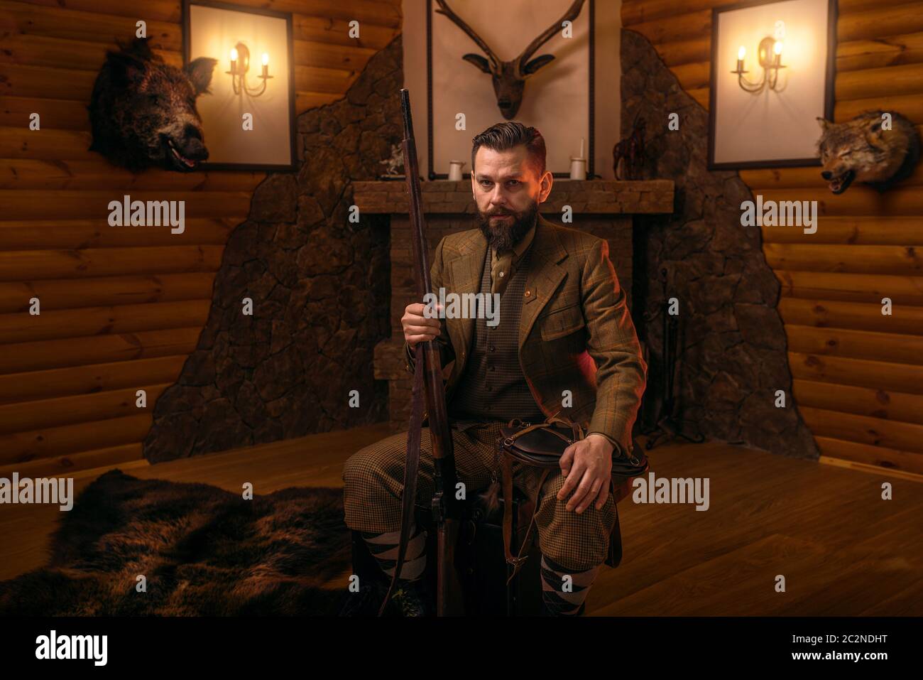 Vintage hunter man in traditional hunting clothing sitting in a chair ...