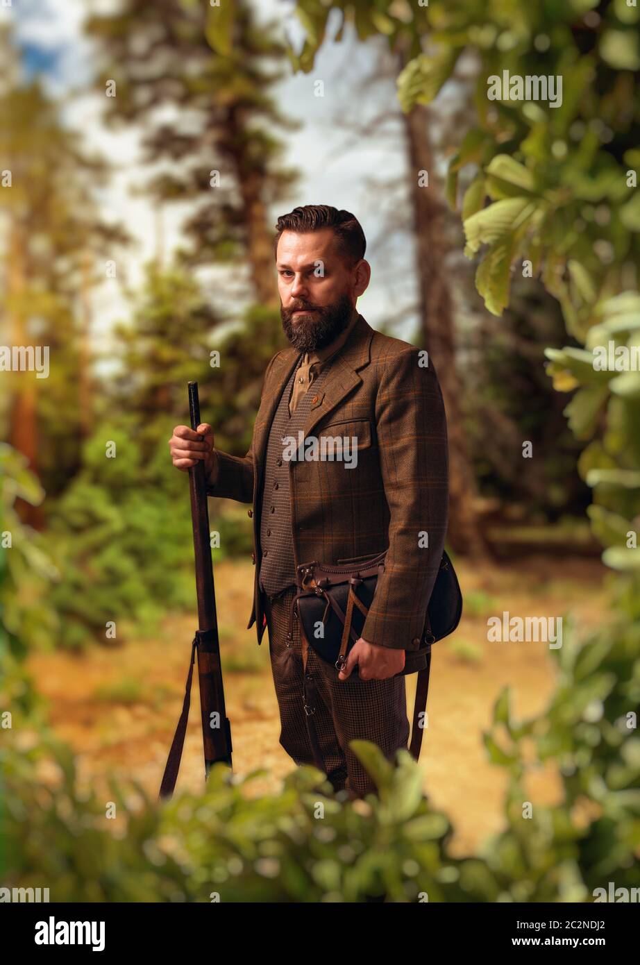 Portrait of breaded hunter man in traditional hunting clothing with old ...