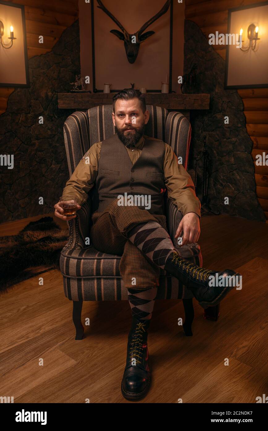 Hunter man in traditional british clothing sitting in a chair after ...