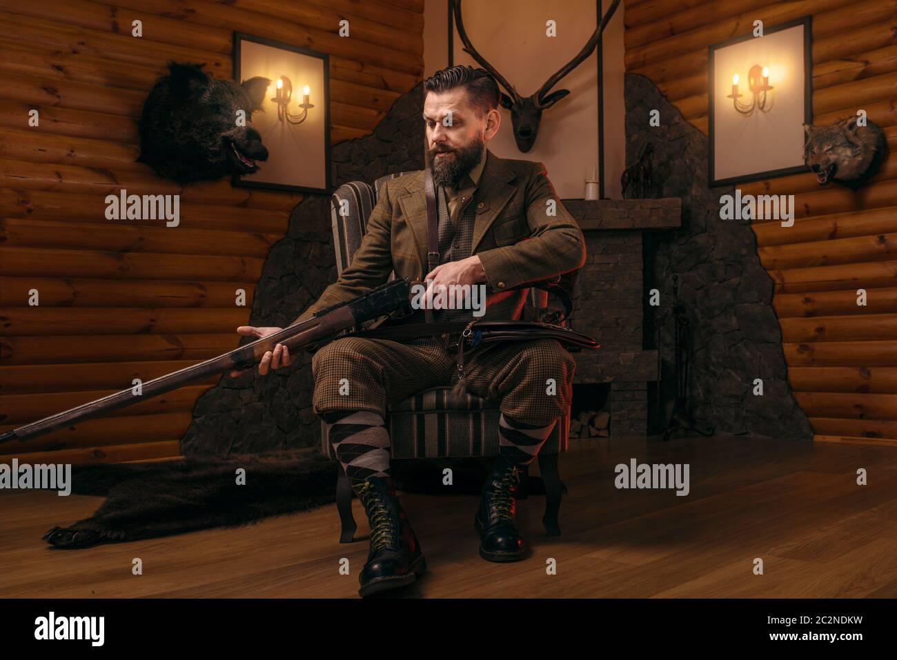 Hunter man in vintage hunting clothing sitting in a chair with antique ...