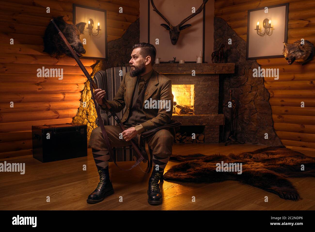 Vintage hunter man in traditional hunting clothing sitting in a chair ...