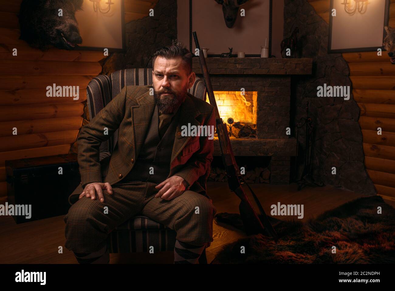Solid male hunter in traditional hunting clothes sitting in a chair ...