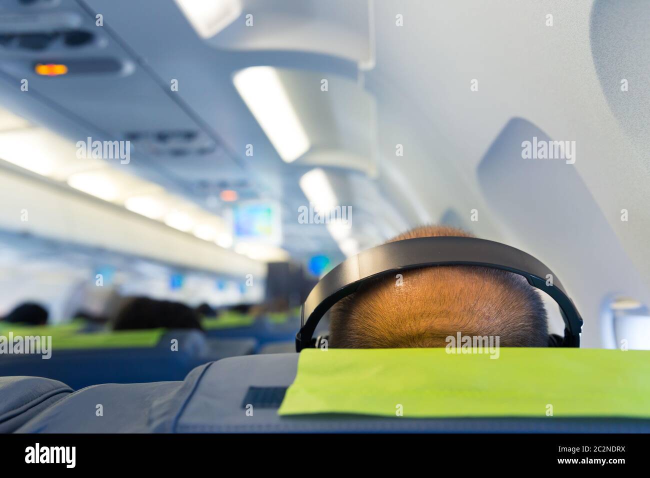 Man's head in headphones in the plane salon close up Stock Photo - Alamy