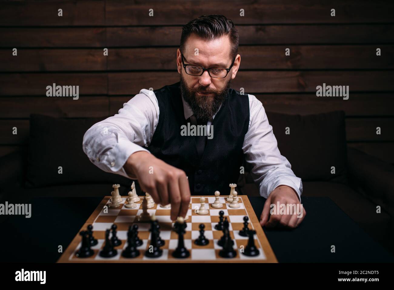 Serious male chess player in glasses makes victory move. Win strategy ...