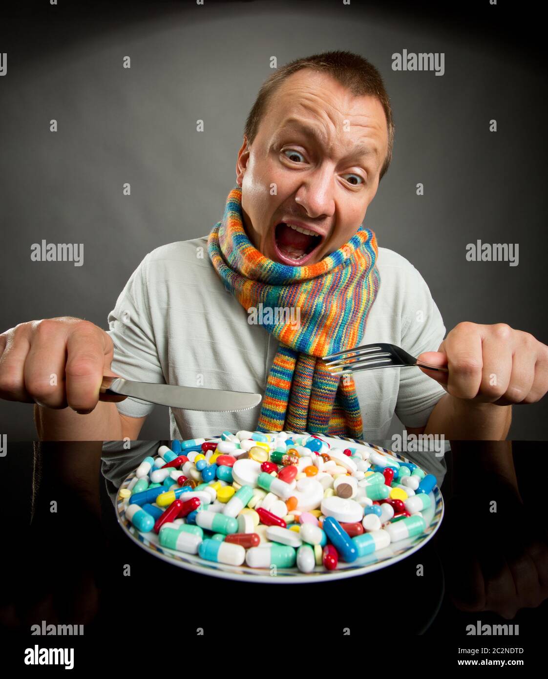 Man eating pills and medicines with fork and knife Stock Photo - Alamy