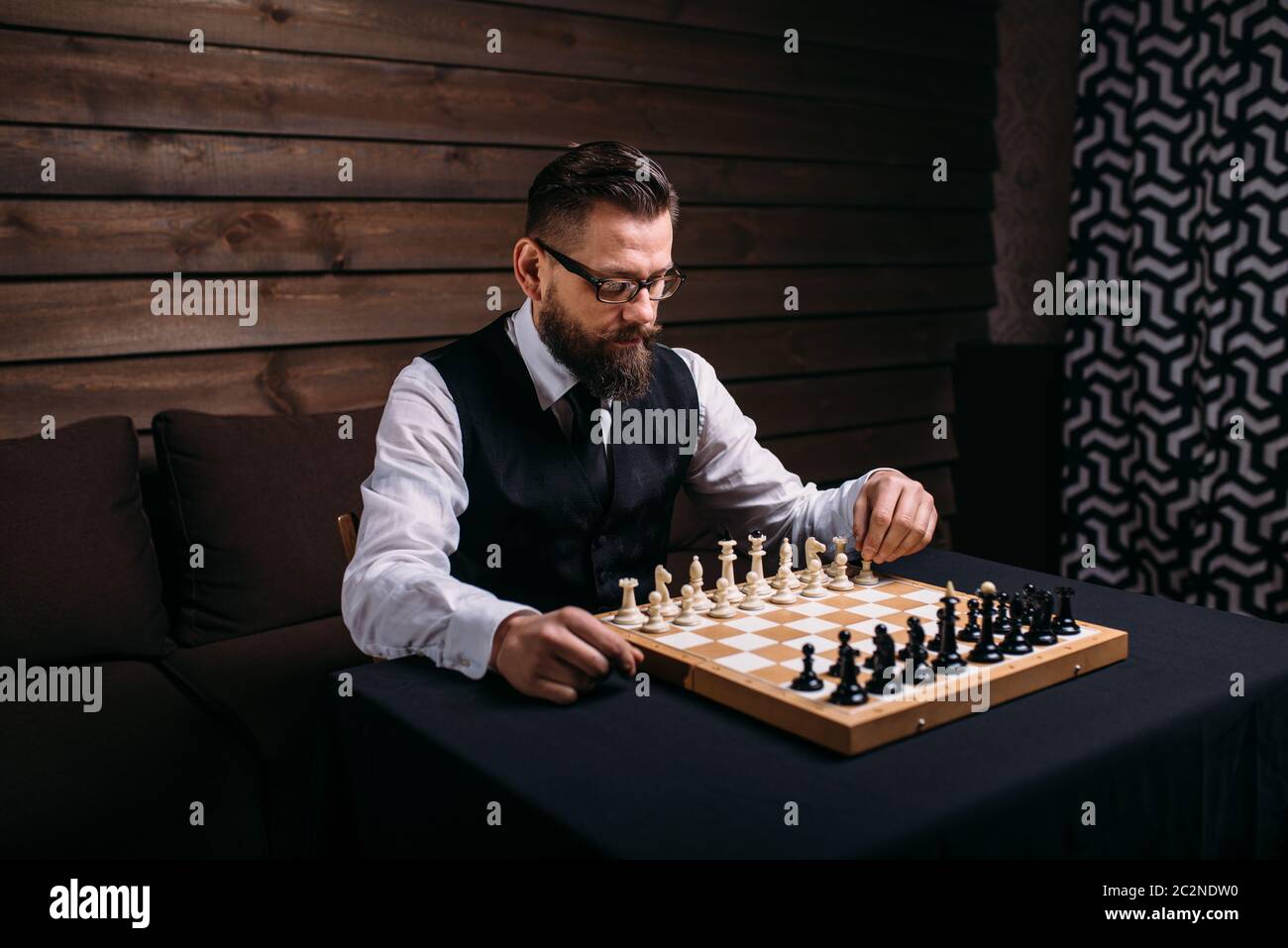 Serious male chess player in glasses makes victory move. Win strategy ...