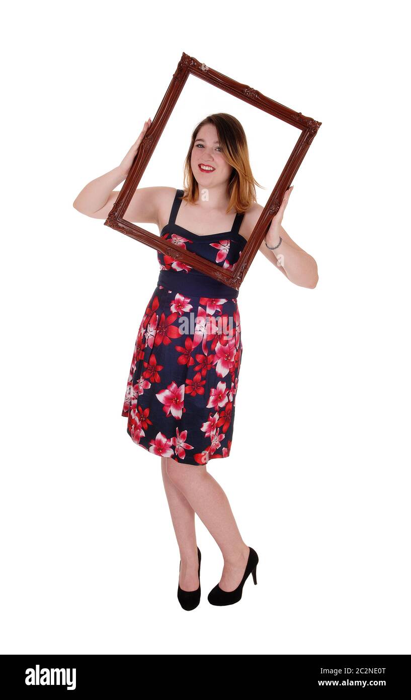 A lovely smiling young woman holding up a picture frame and looking ...