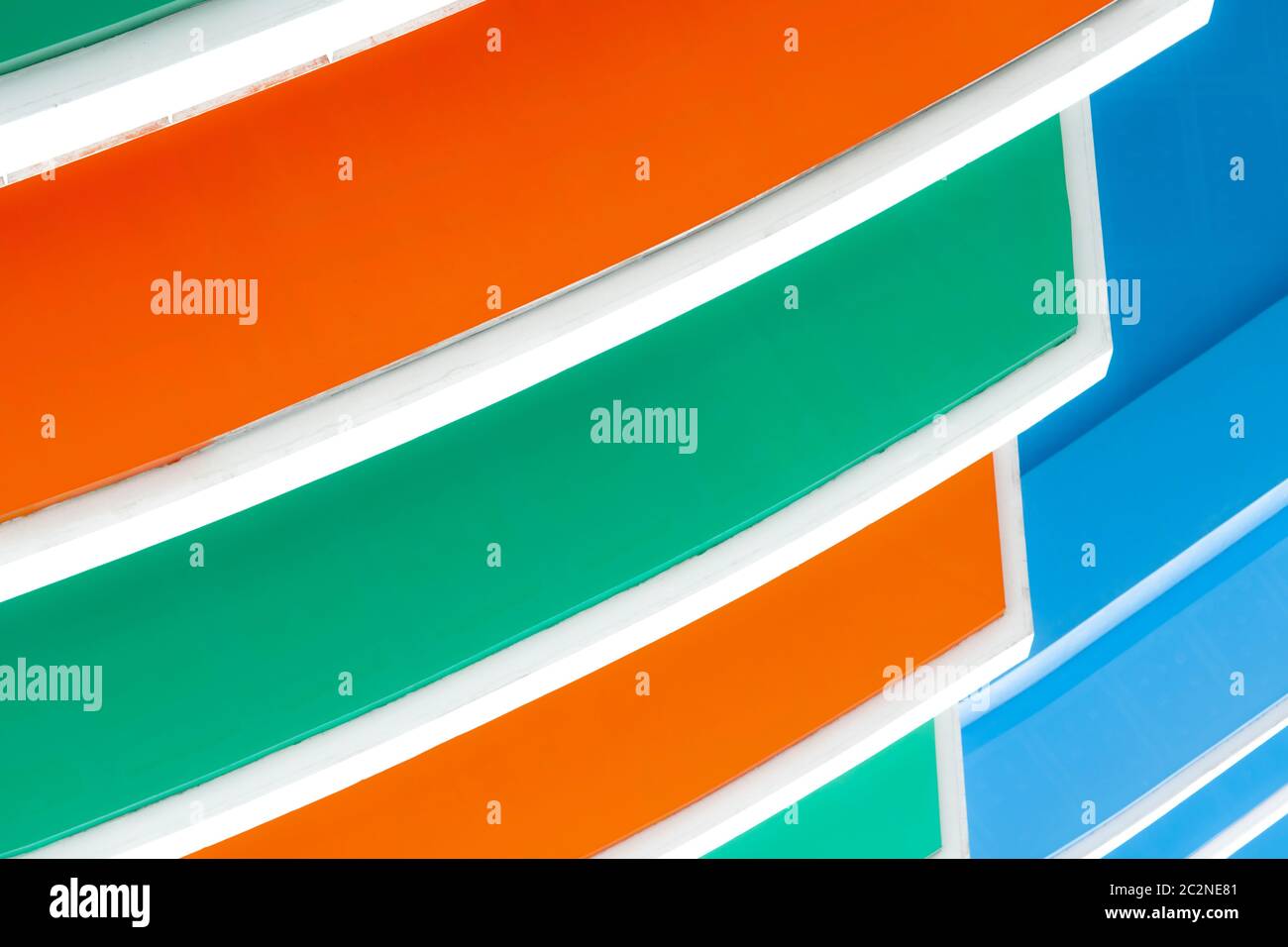 Closeup facade of concrete building. Orange, white, green, and blue ...