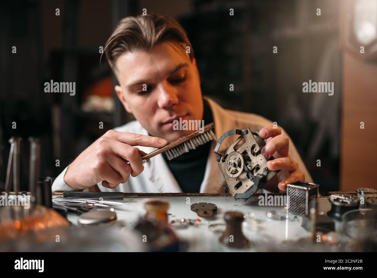 Watchmaker cleans the mechanism of old watches. Clock maker at work ...