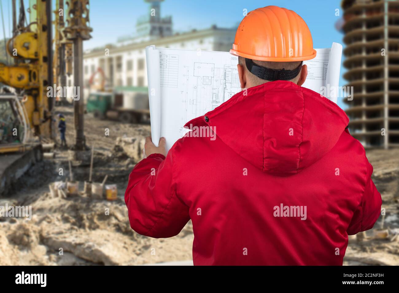 Contractor reading plans against construction site Stock Photo - Alamy