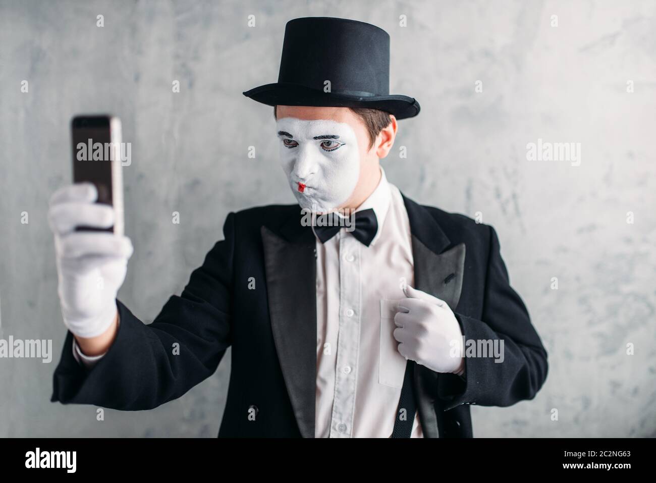Pantomime actor with makeup mask makes selfie on camera. Comedy artist ...