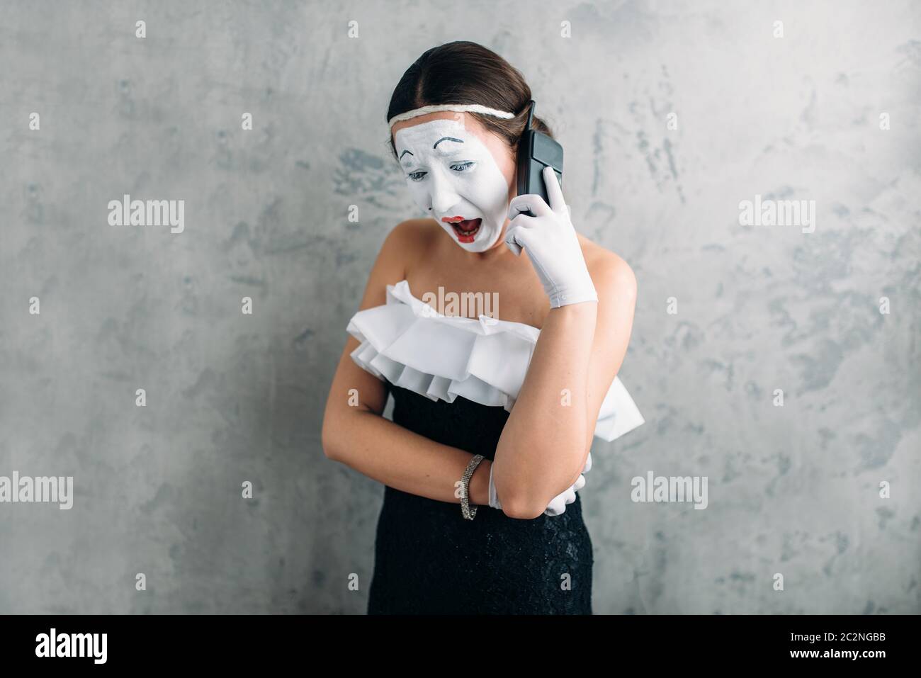 Mime actress performing with mobile phone. Comedy female artist posing ...