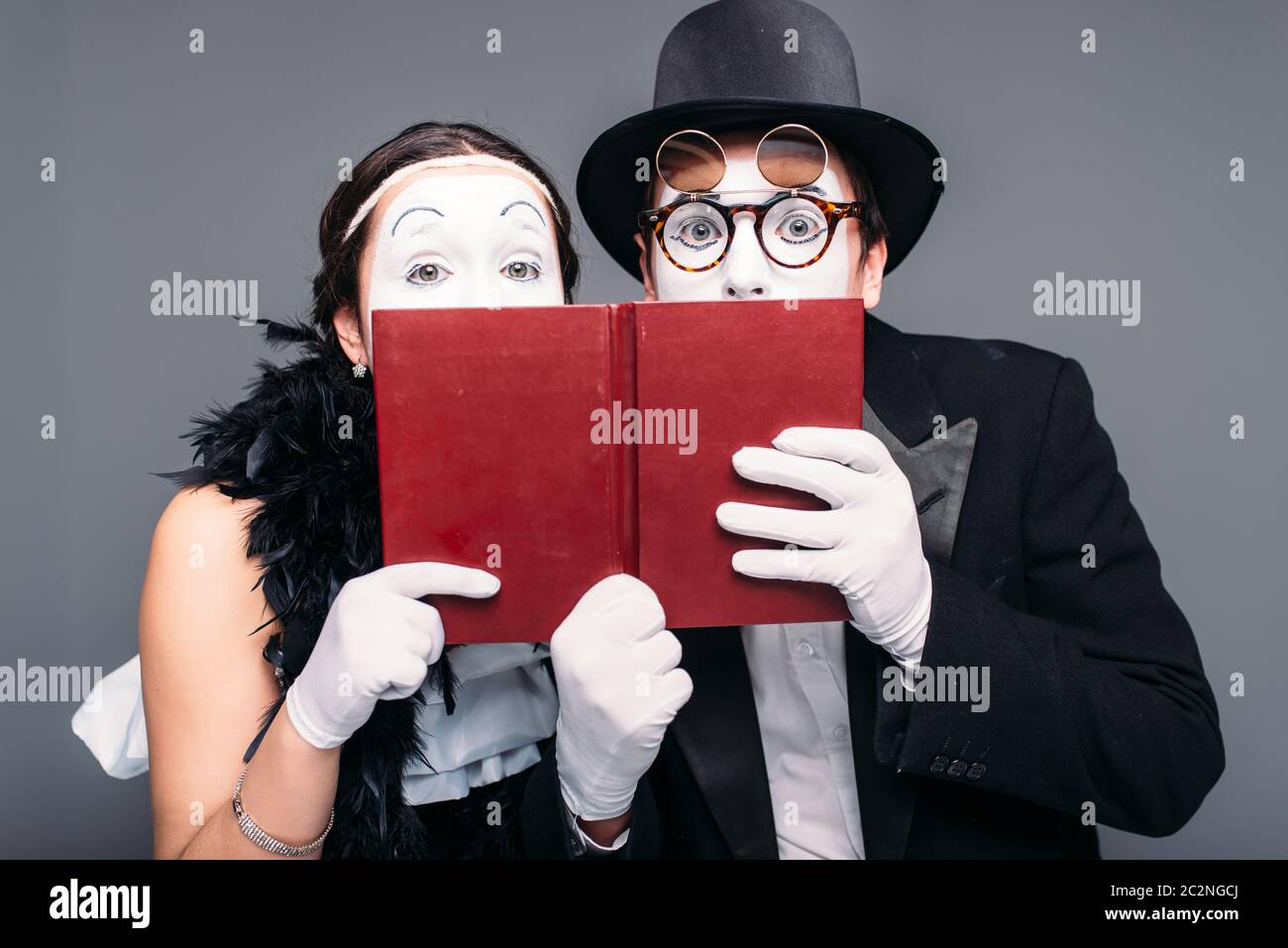 Two comedy performers posing with book. Pantomime theater actor and ...