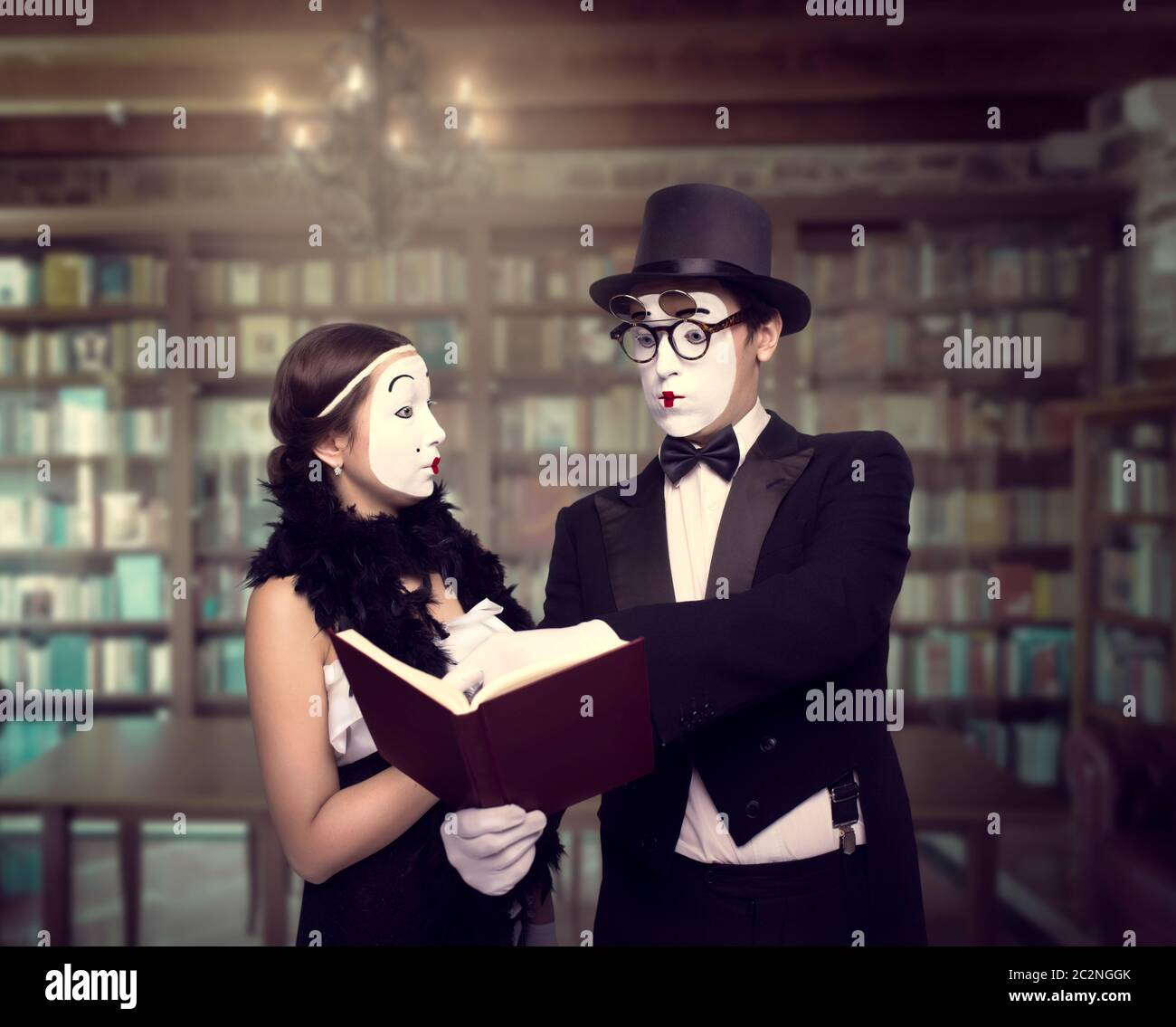 Two pantomime theater performers posing with book. Mime actor and ...