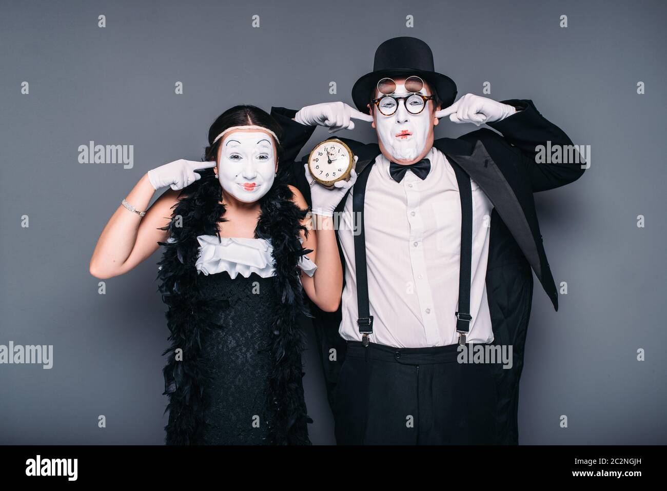 Pantomime actors performing with alarm clock. Comedy artist and actress ...